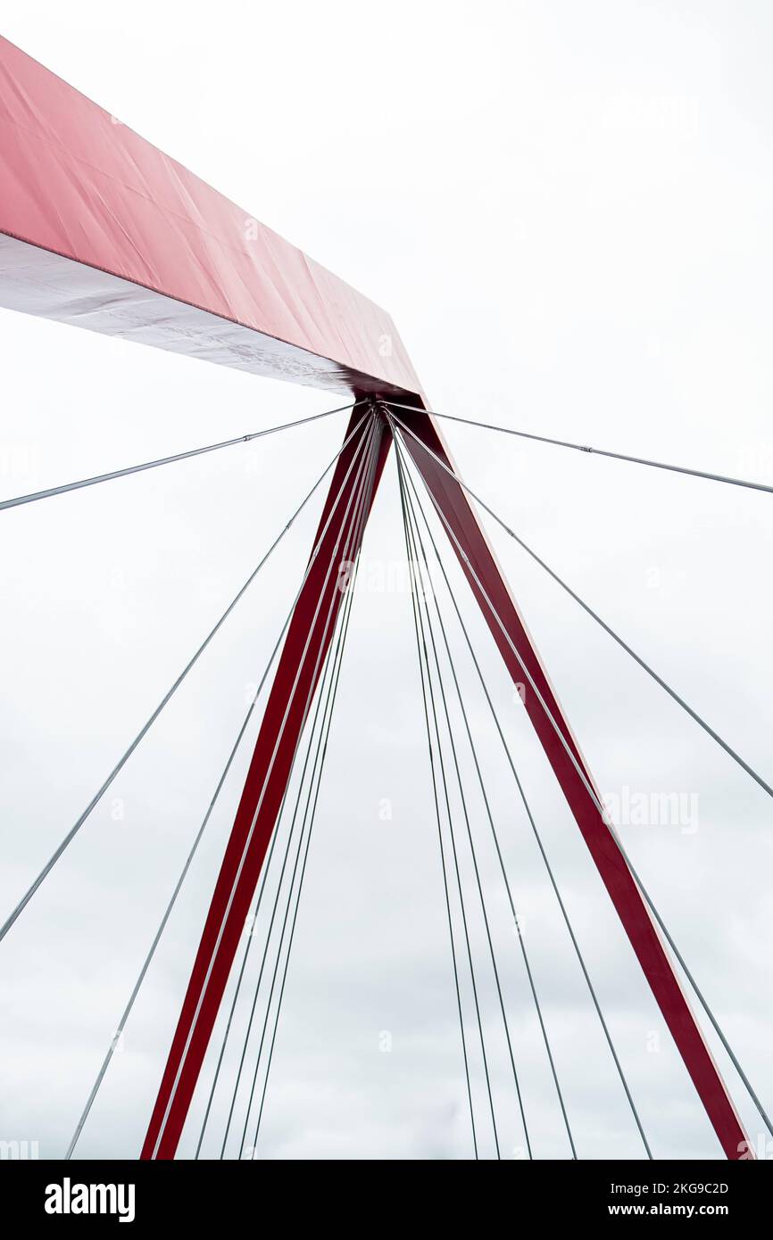 A low angle shot of a structure with wires and red frames against the ...