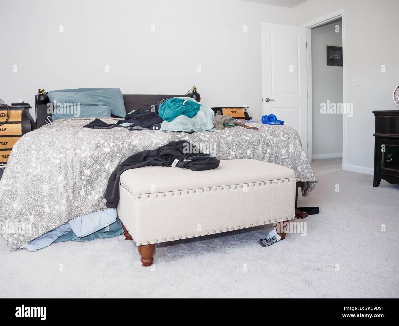 Picture of bedroom with everyday life. Bed untidy, clothes on the end ...