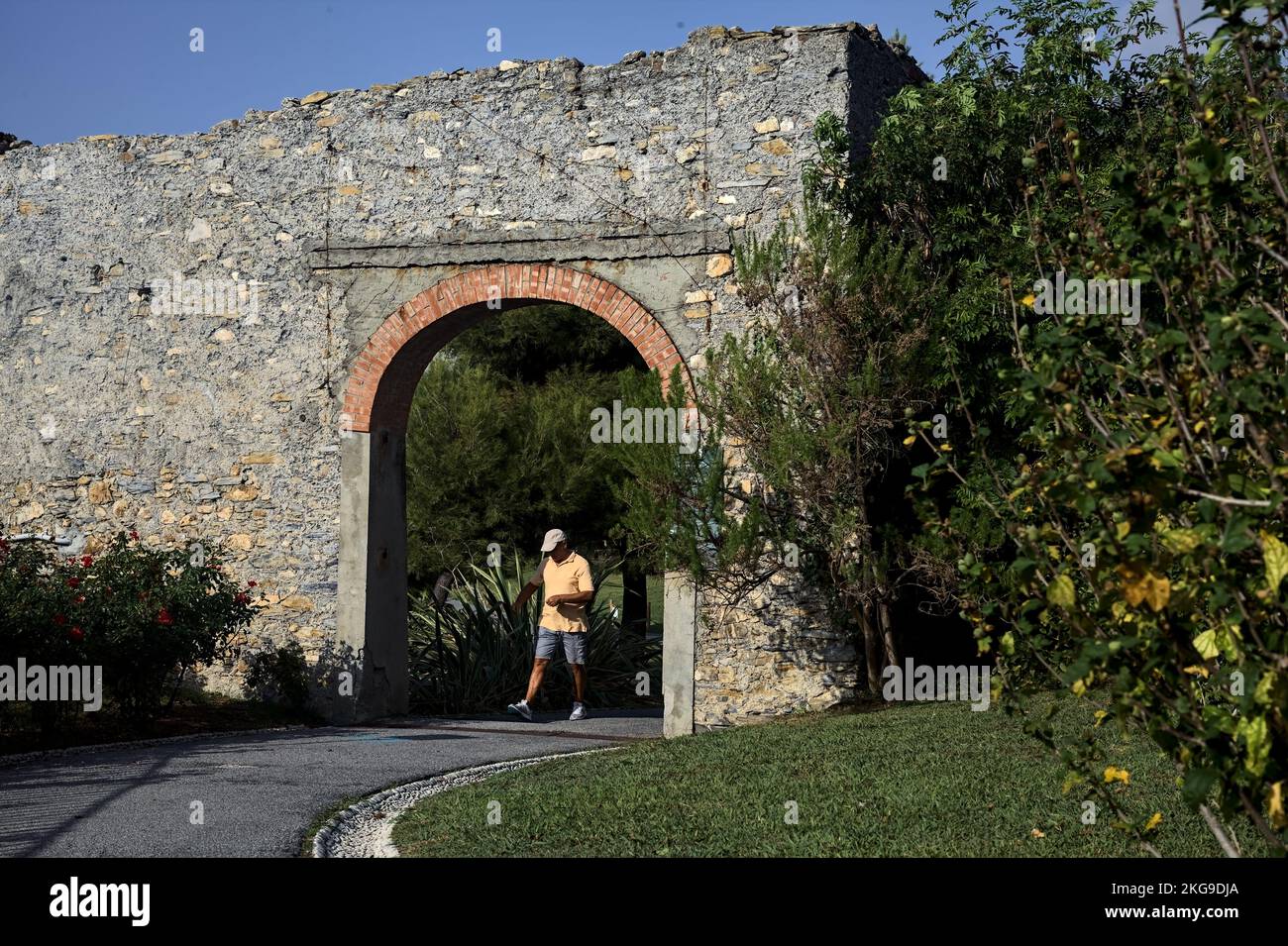 Path going through an arch of an ancient bounday wall in a park Stock ...