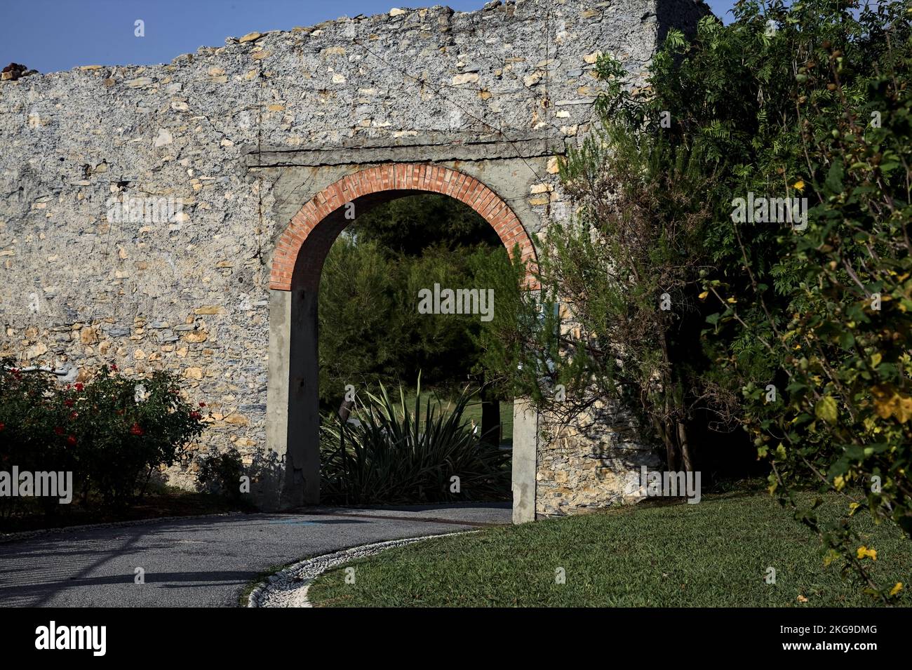 Path going through an arch of an ancient bounday wall in a park Stock ...