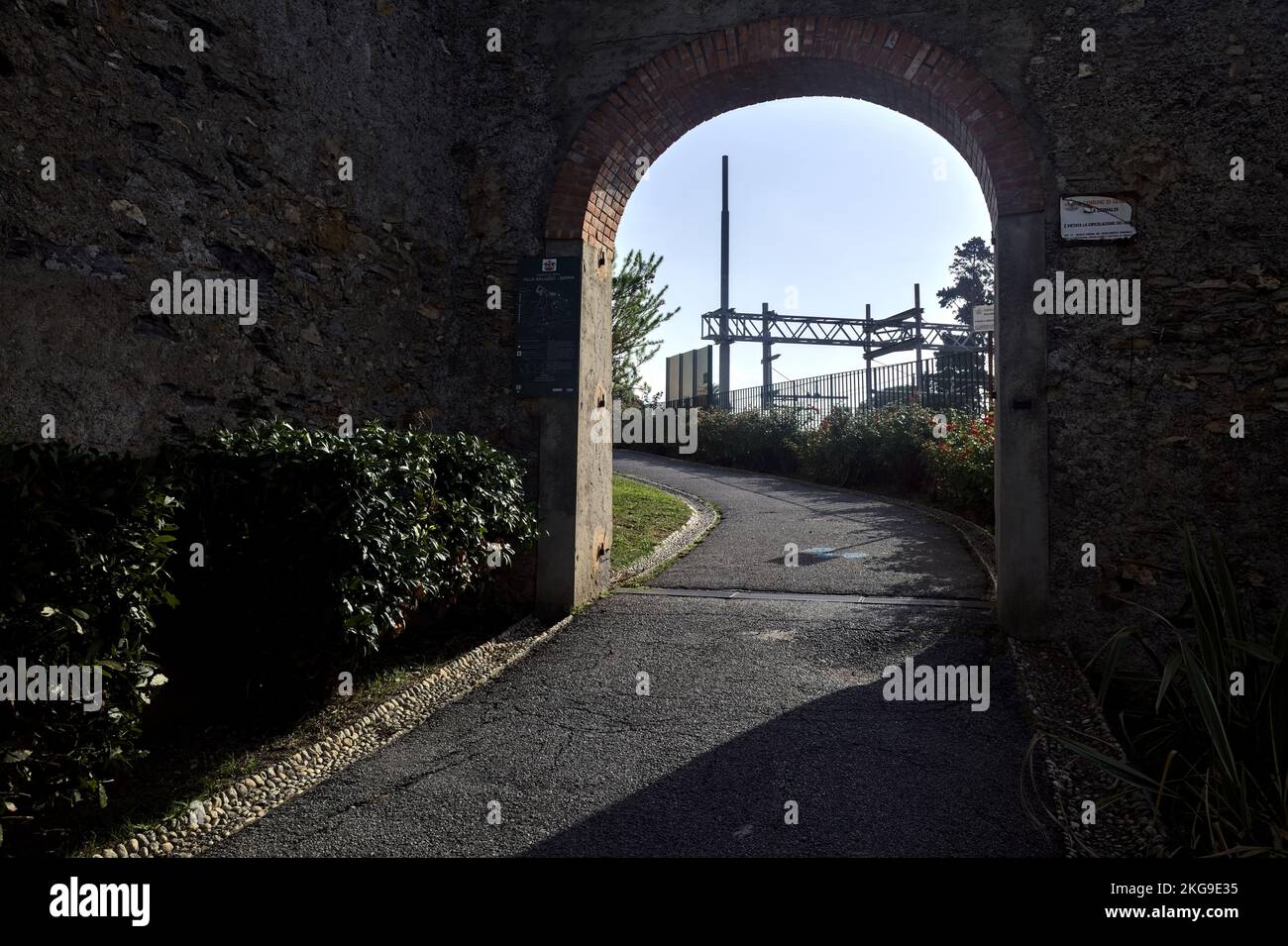 Path going through an arch of an ancient bounday wall in a park Stock ...