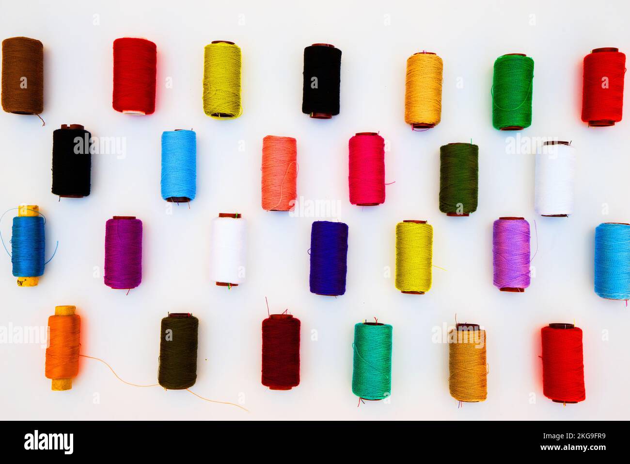 Multi-color silk thread coils on white background Stock Photo - Alamy