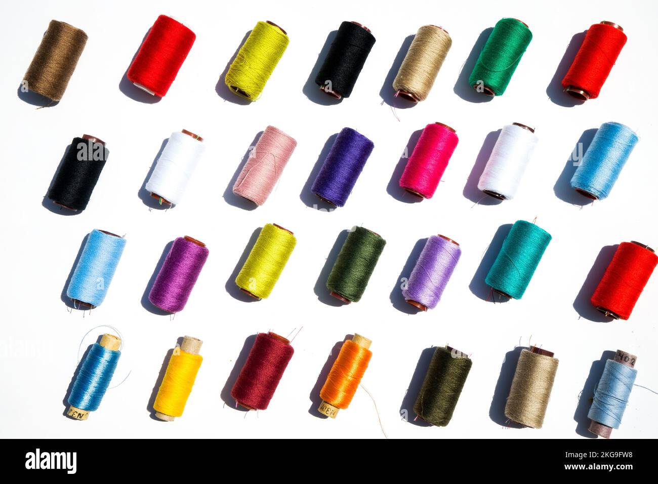 Multi-color silk thread coils on white background Stock Photo - Alamy