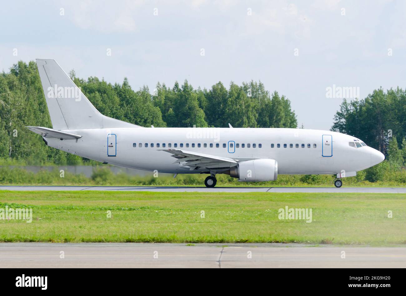 Runway at the airport and a passenger plane on it. Side view Stock ...