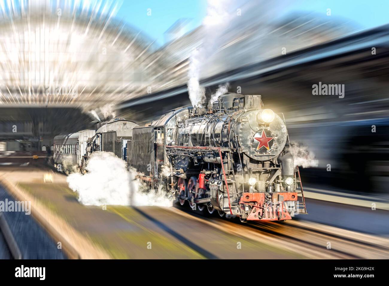 Old steam train locomotive driving past the passenger platform of the ...