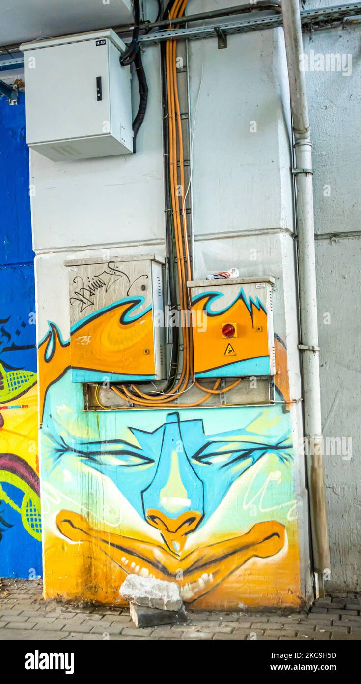 Colorful mural depicting face over electric cables hub on the wall ...