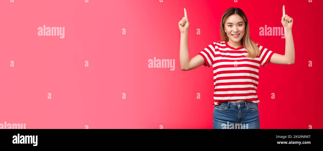 Hey up we go. Cheerful good-looking young asian girl pointing hands up ...