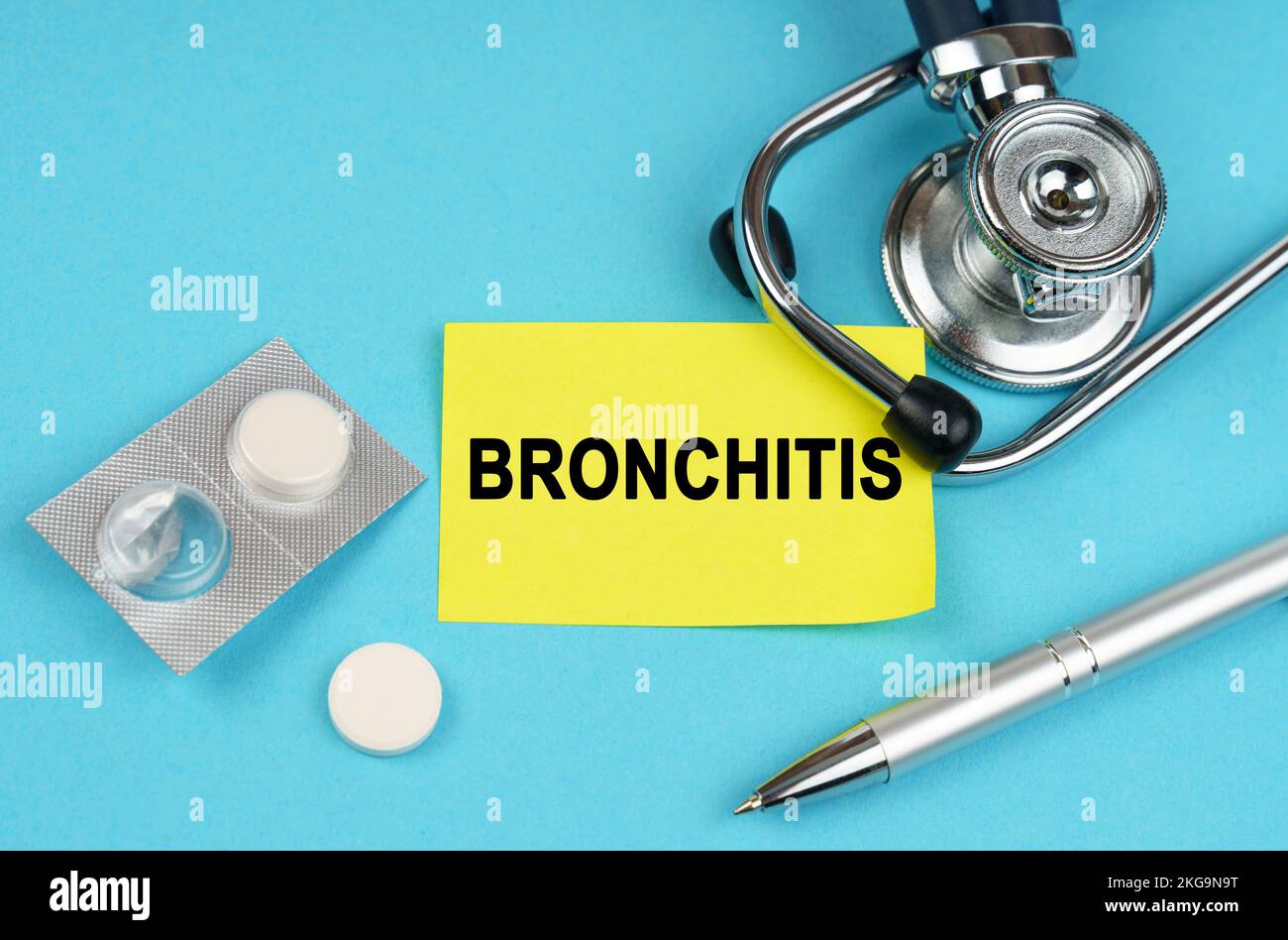Medical concept. On a blue surface, a stethoscope, pills, a pen and a ...