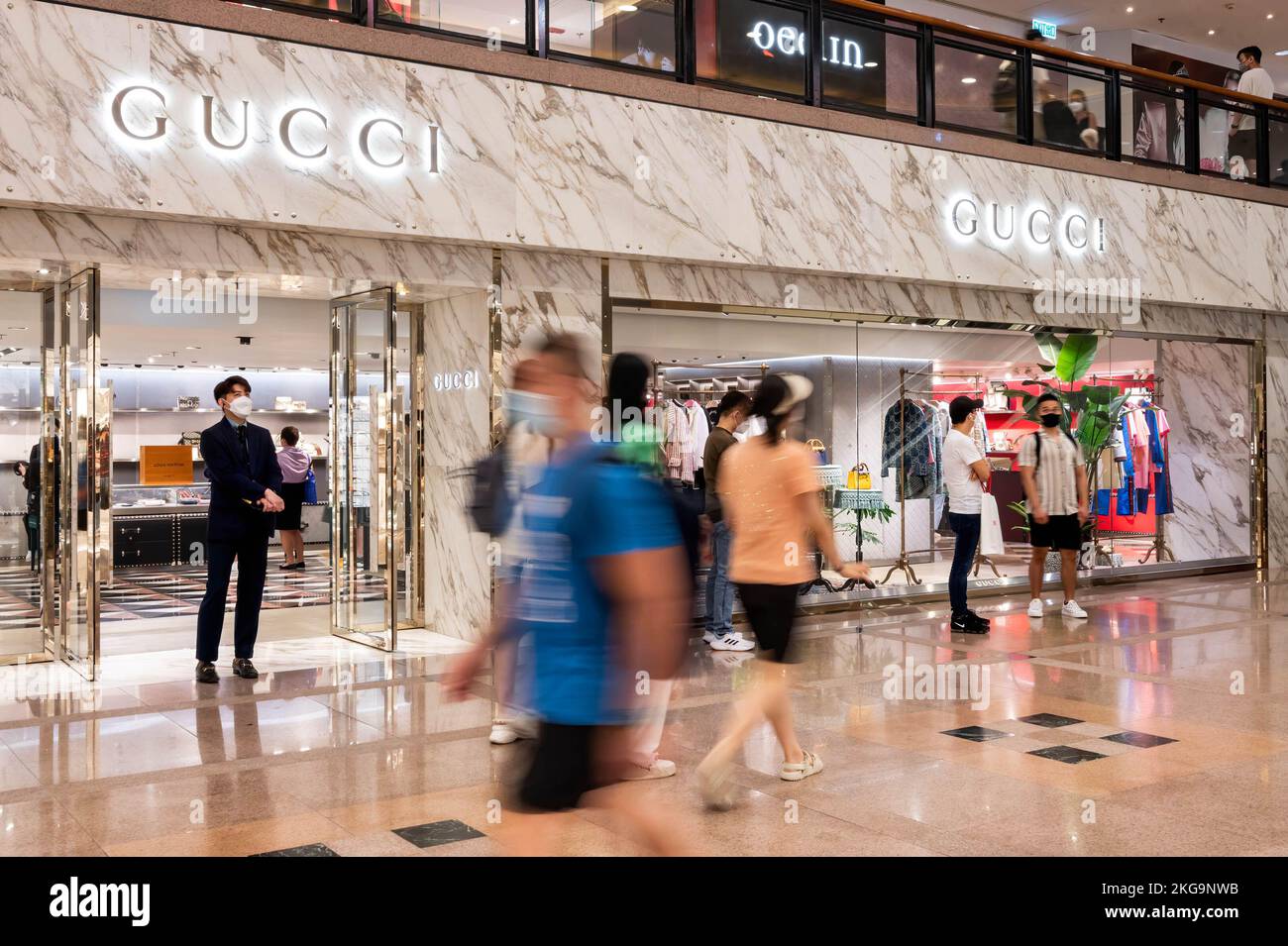 Shoppers walk past the Italian luxury fashion brand Gucci store and ...