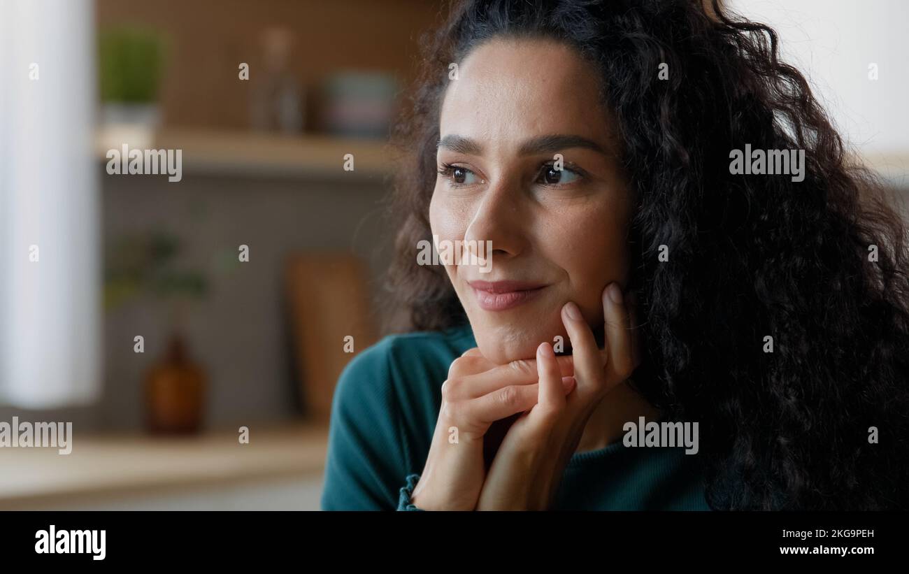 Close up head shot portrait peaceful beautiful young woman relaxing at home put chin on folded ...