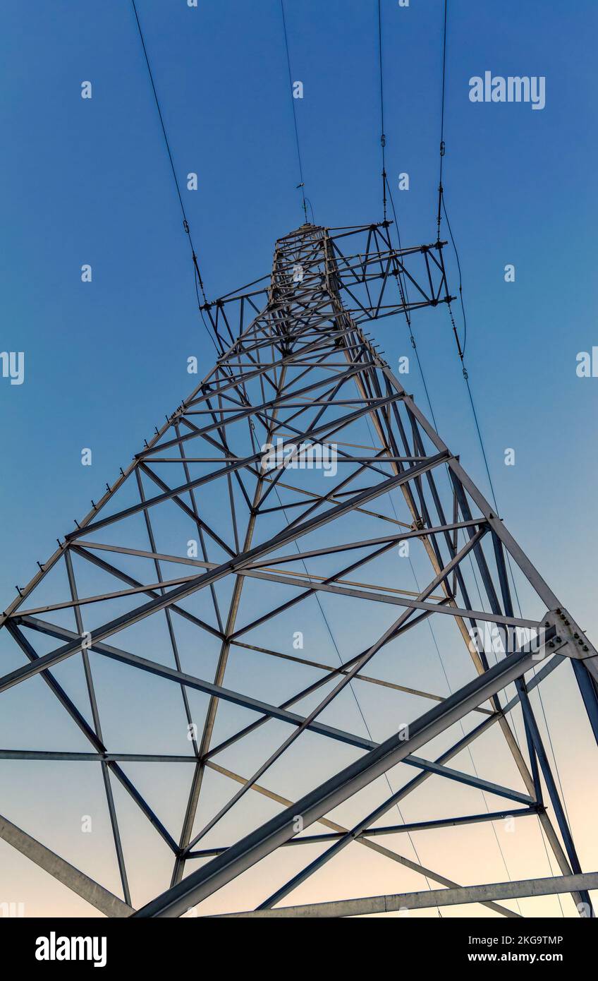 High voltage power lines pylons and electrical cables against the ...