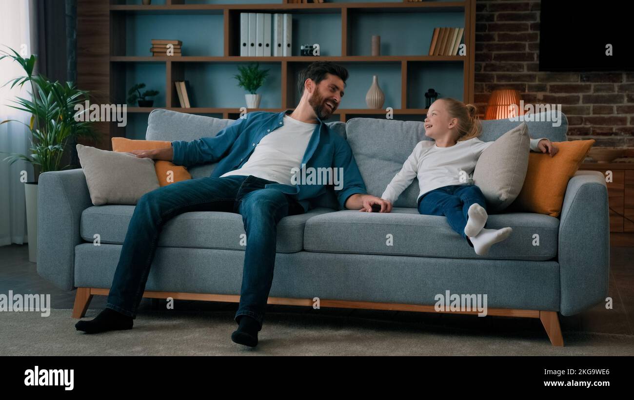 Happy caucasian young family daddy and child daughter jumping on soft ...