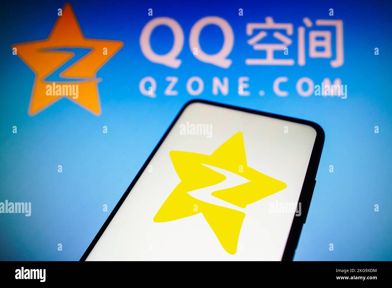 In this photo illustration, the QZone logo is displayed on a smartphone screen and in the ...