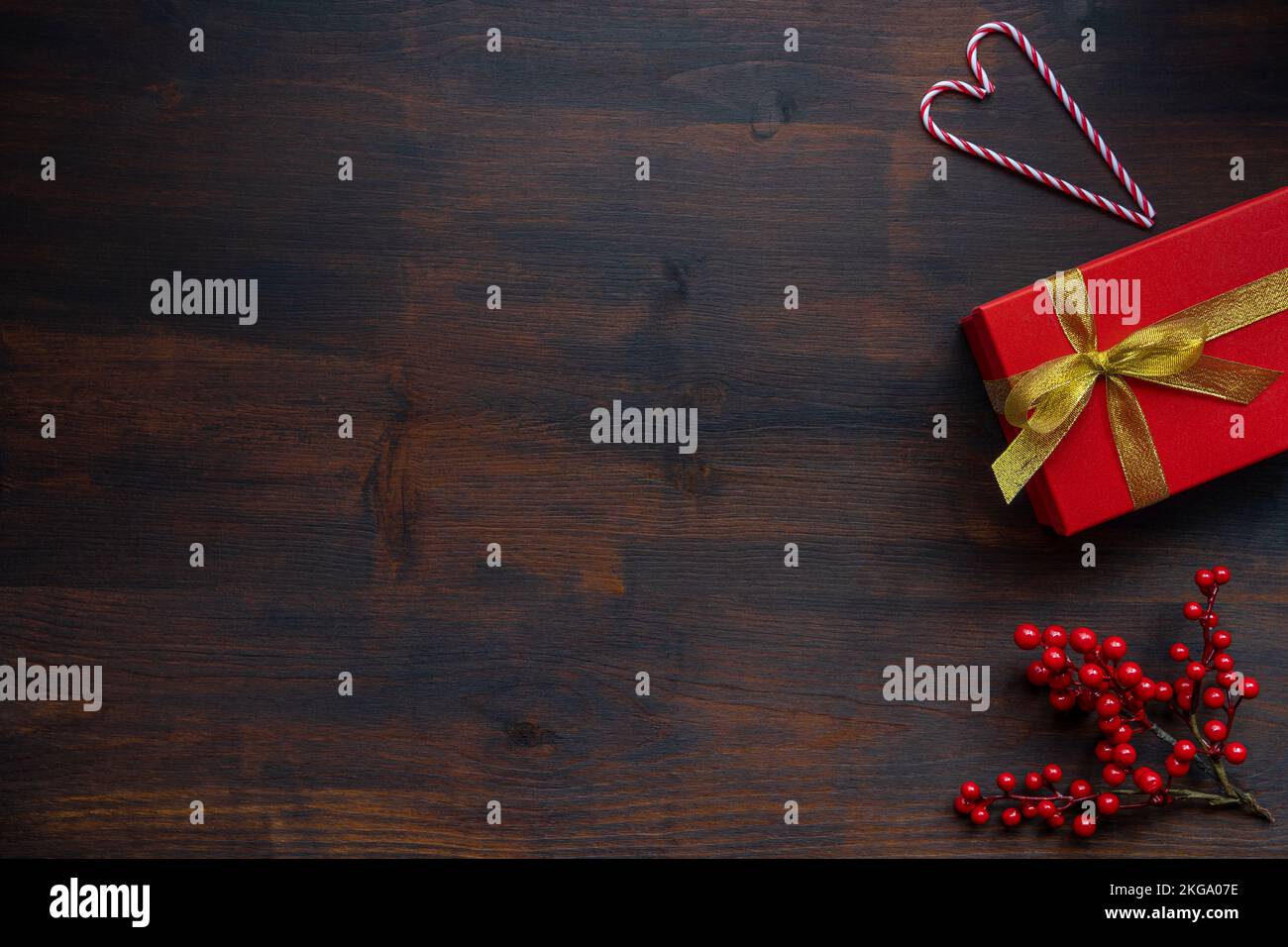 red gift box with gold ribbon on a dark wooden background with red ...