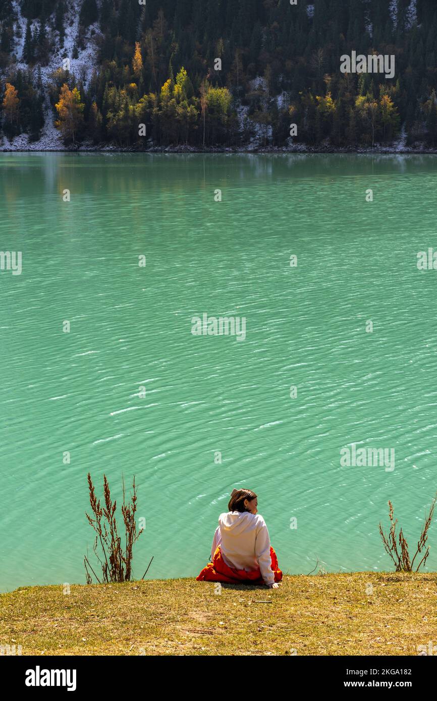 Lone tourist sitting at Issyk Lake, South Kazakhstan, Central Asia ...