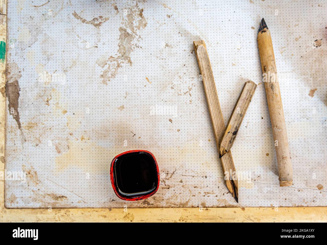 Black ink and sharpened sticks for calligraphy or drawings on a smeared ...