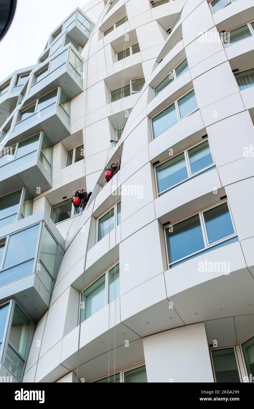 window washers cleaning the glass facade of a skyscraper, high risk ...