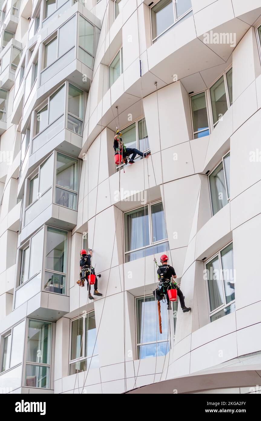 window washers cleaning the glass facade of a skyscraper, high risk ...