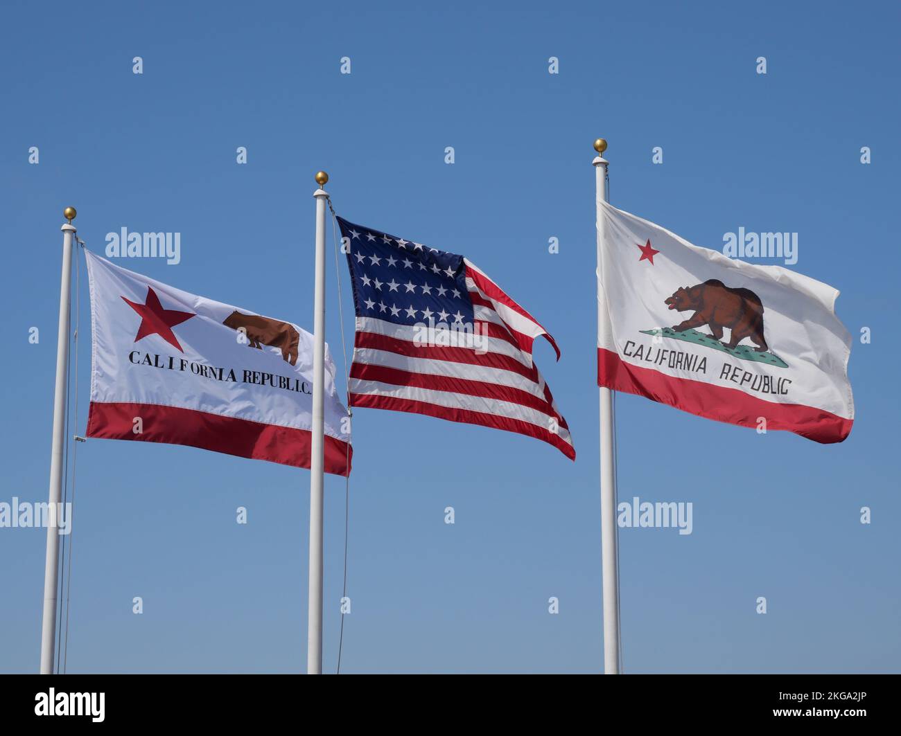 Flags of California and the United States of America against a clear ...