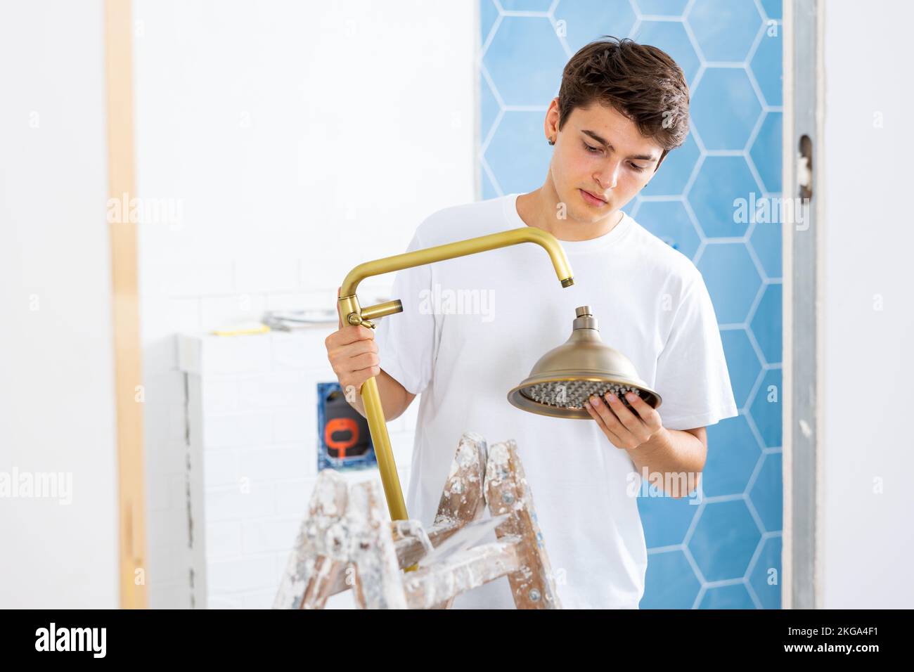 Guy preparing new shower for installation in building under ...
