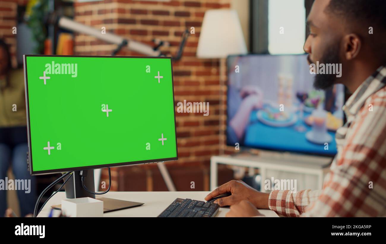 Buisnessman analyzing greenscreen display on monitor, looking at ...