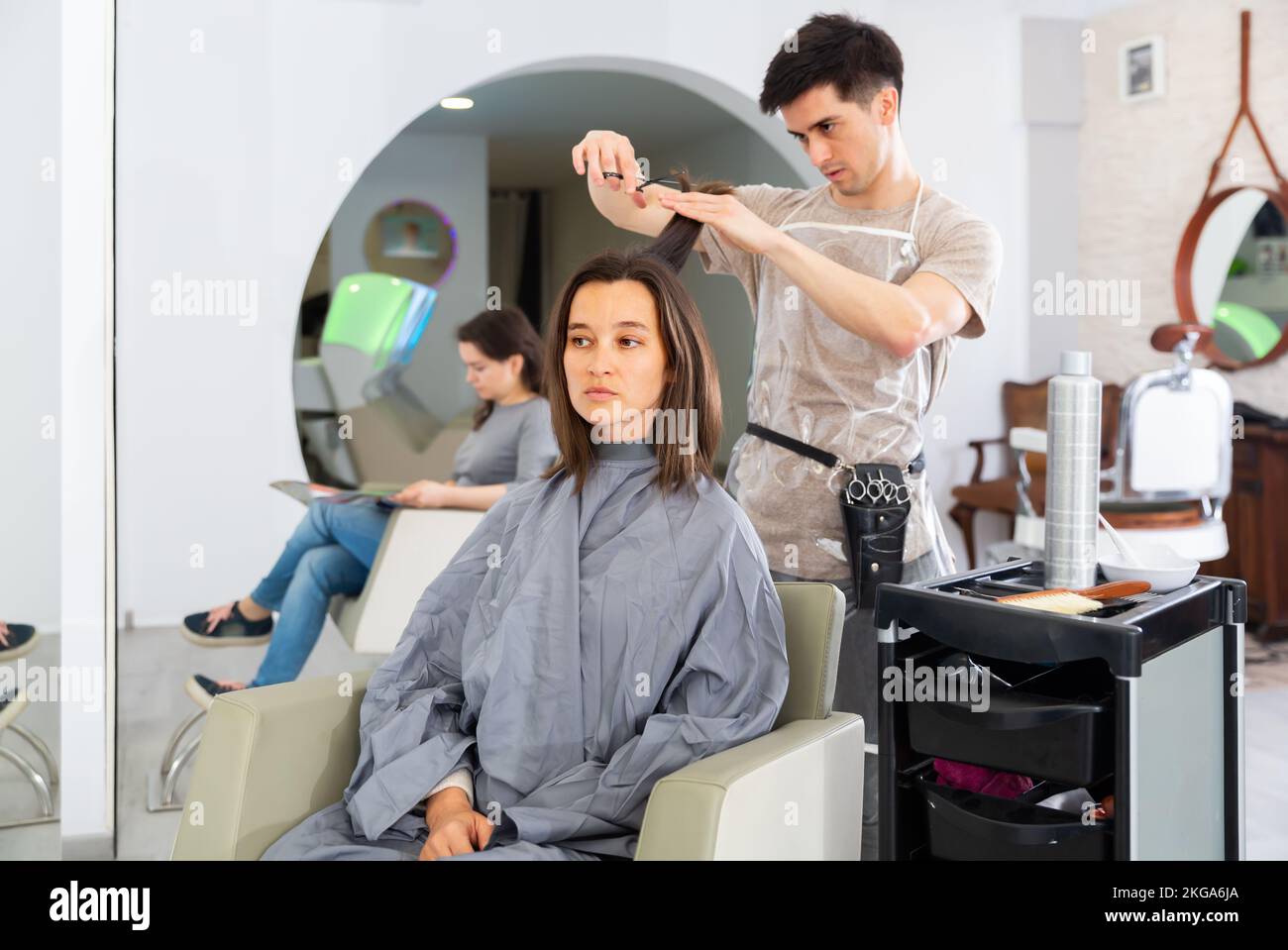 Fine hairdresser and client getting haircut Stock Photo - Alamy