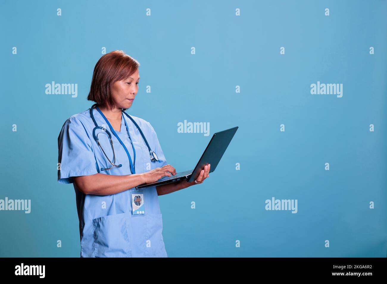 Senior physician nurse holding laptop computer checking medical ...