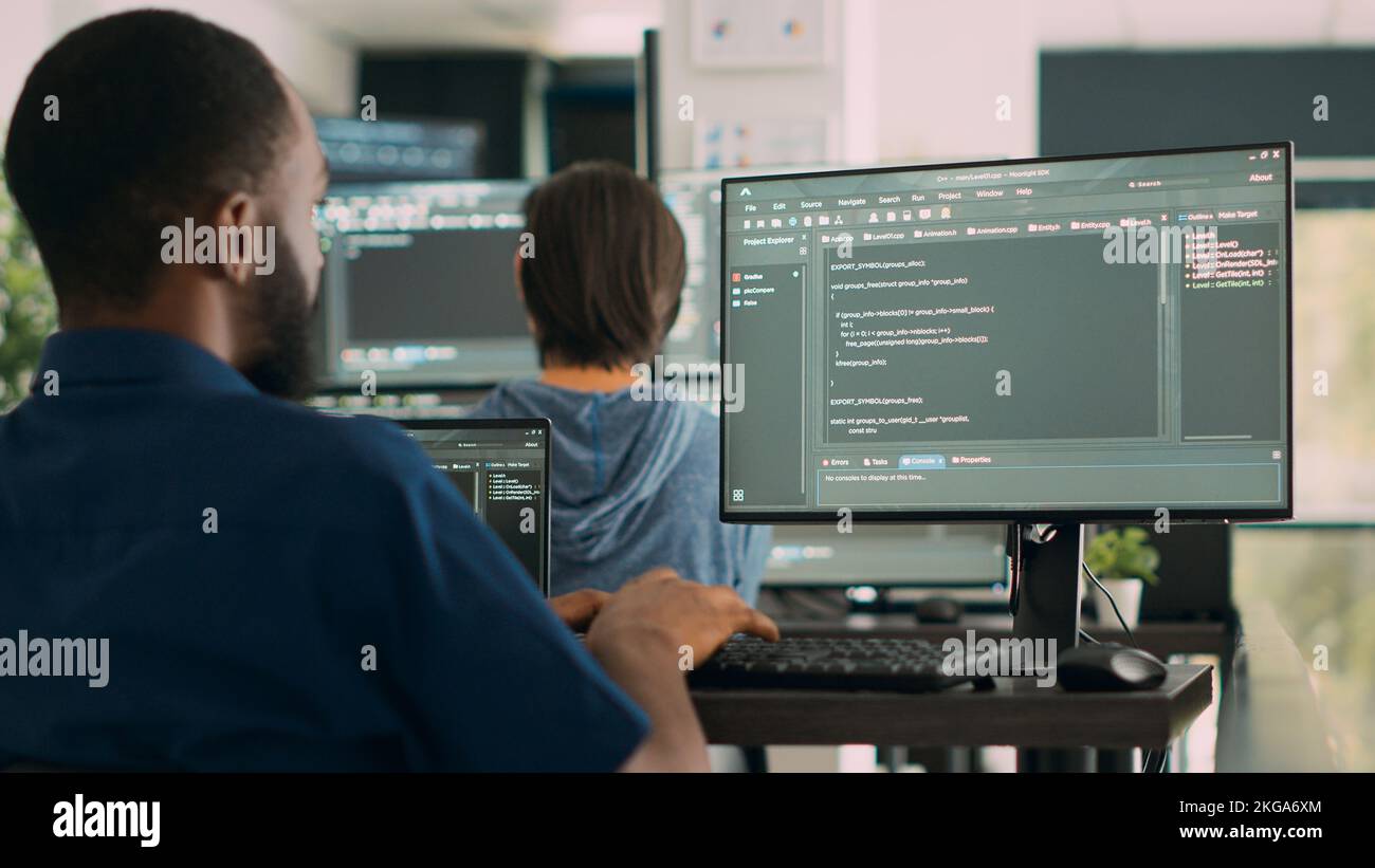 African american system engineer working on software development with source code, looking at ...