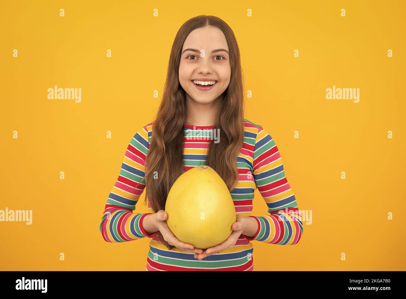 Teenager child girl hold citrus fruit pummelo or pomelo full of vitamin ...