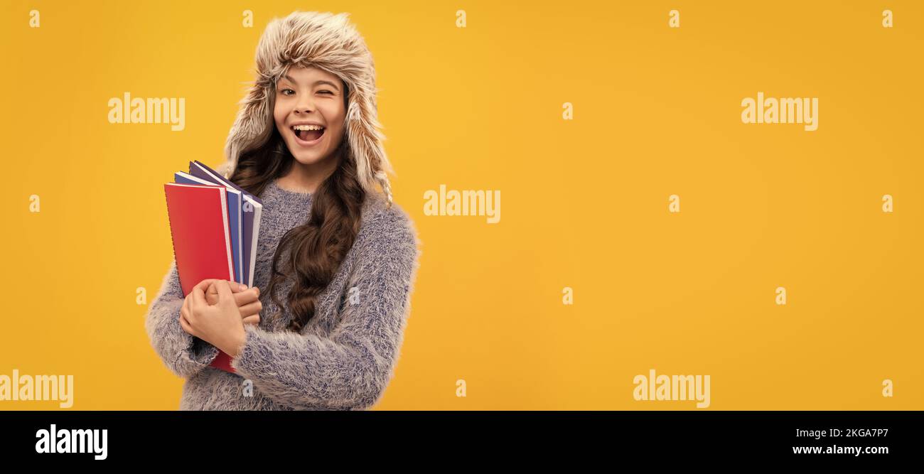 happy winking kid long hair in hat with copybook on yellow background ...