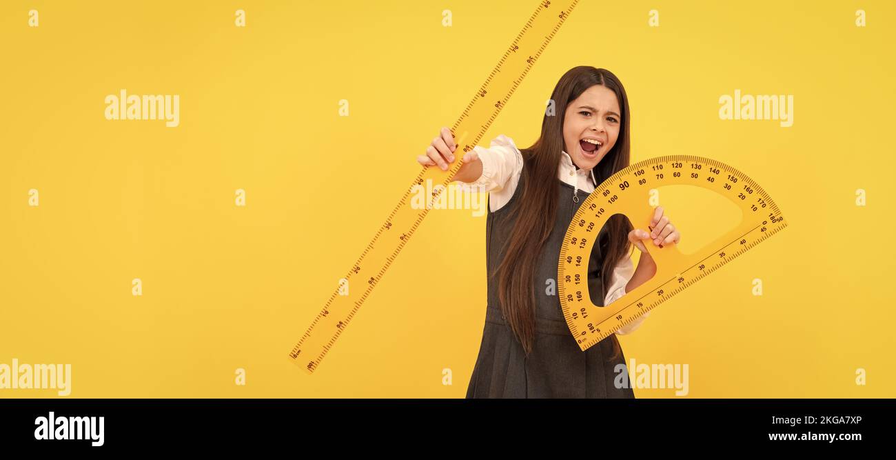 emotional child hold math protractor and ruler in school on yellow ...