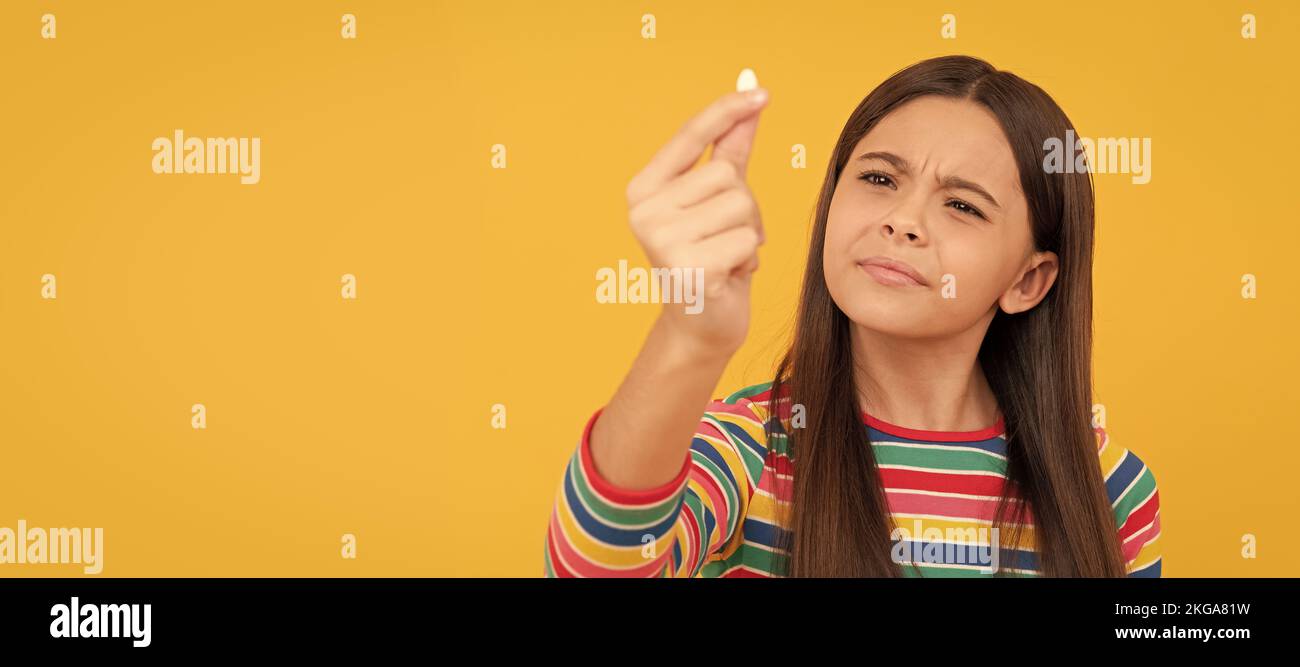 curious child look at pill. capsule shape tablet for kids. girl hold ...