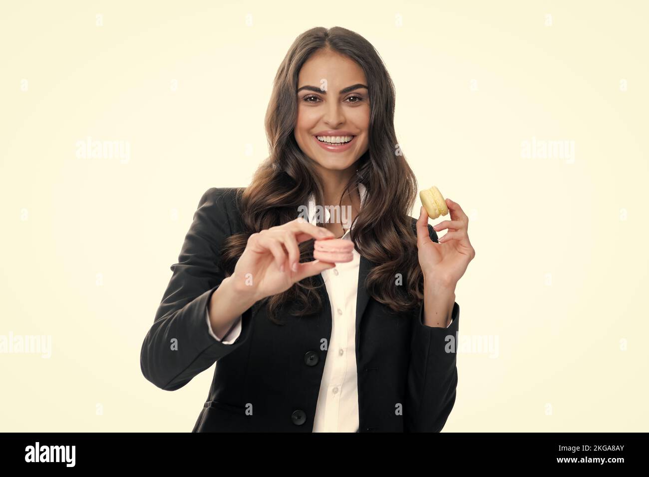 Woman eating a macaroon. Beautiful redhead woman in summer straw hat ...