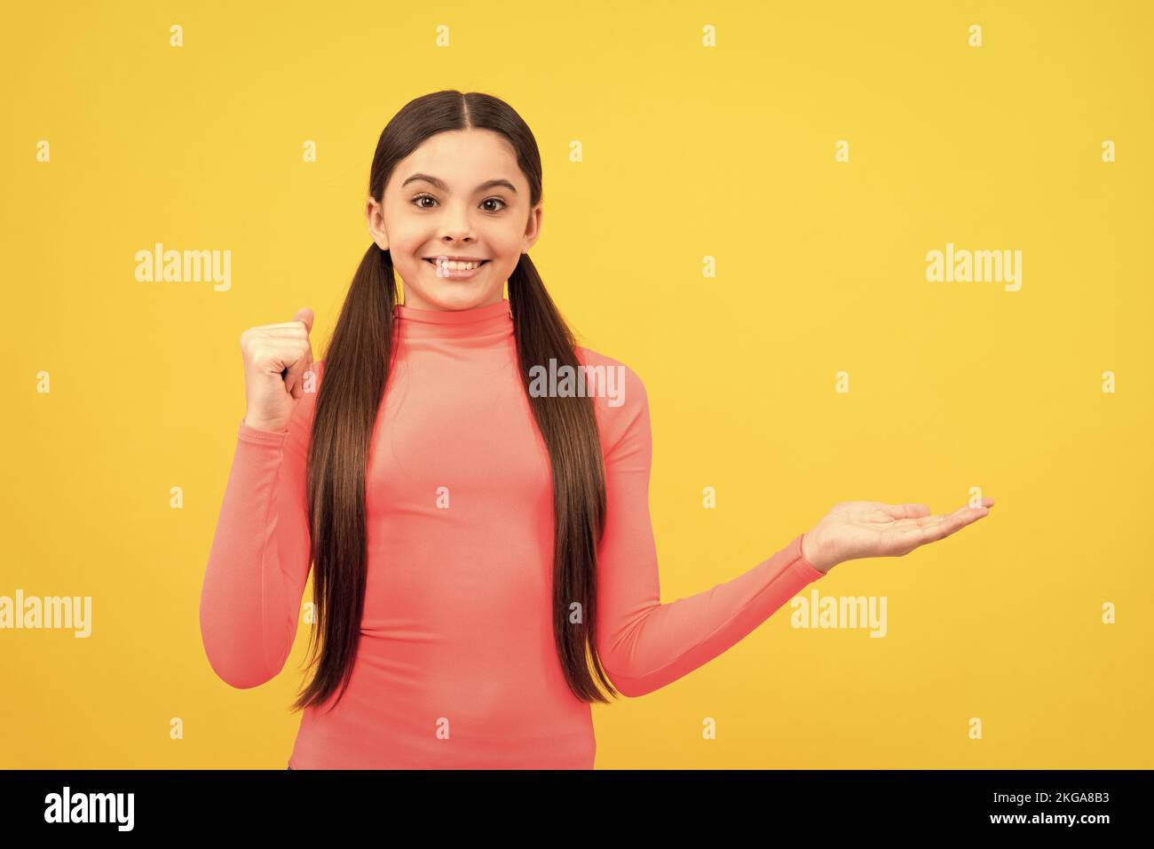smiling kid presenting product, copy space. pretty teen girl ...