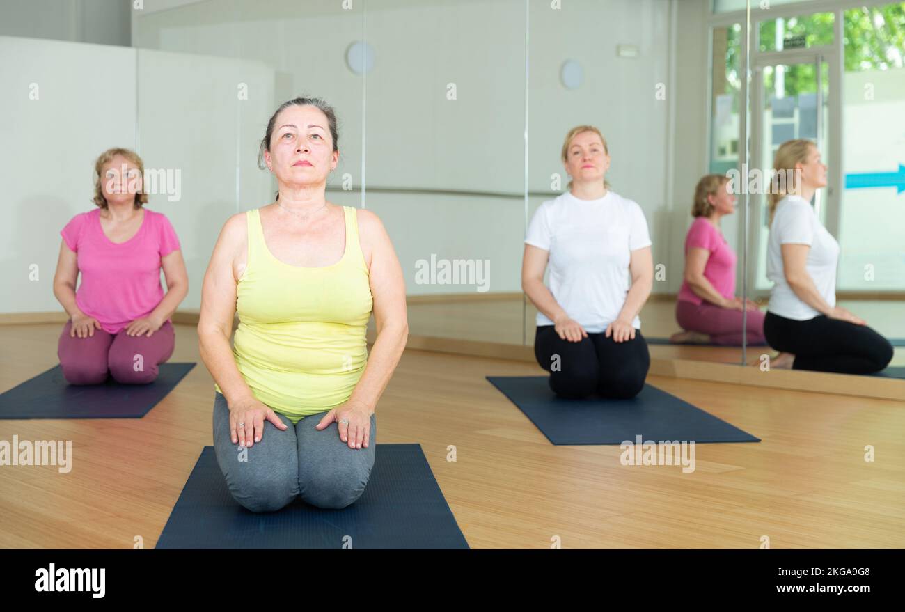 Women are doing hero pose Stock Photo - Alamy