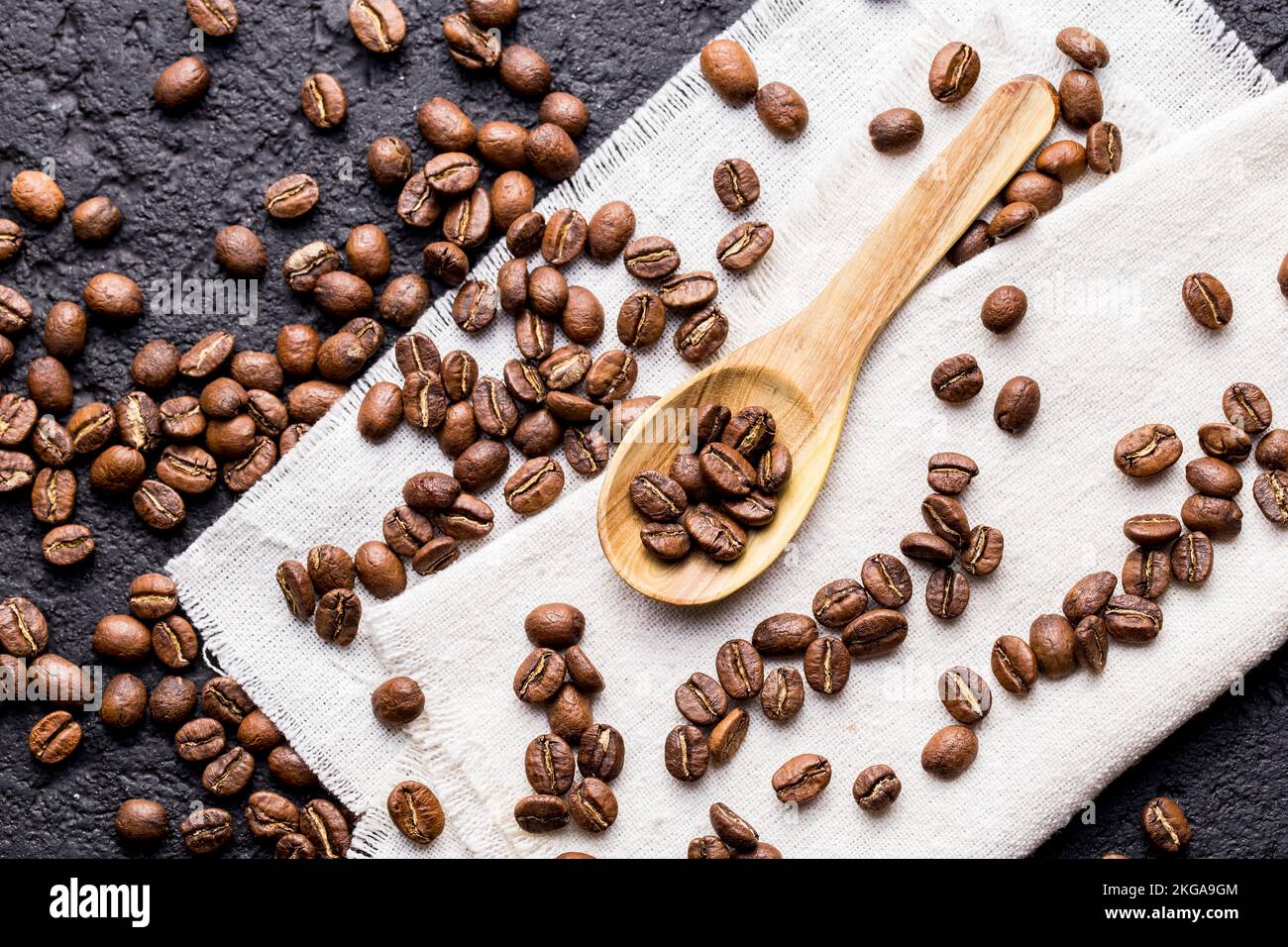 Roasted coffee beans with wooden spoon, closeup image, space for text ...