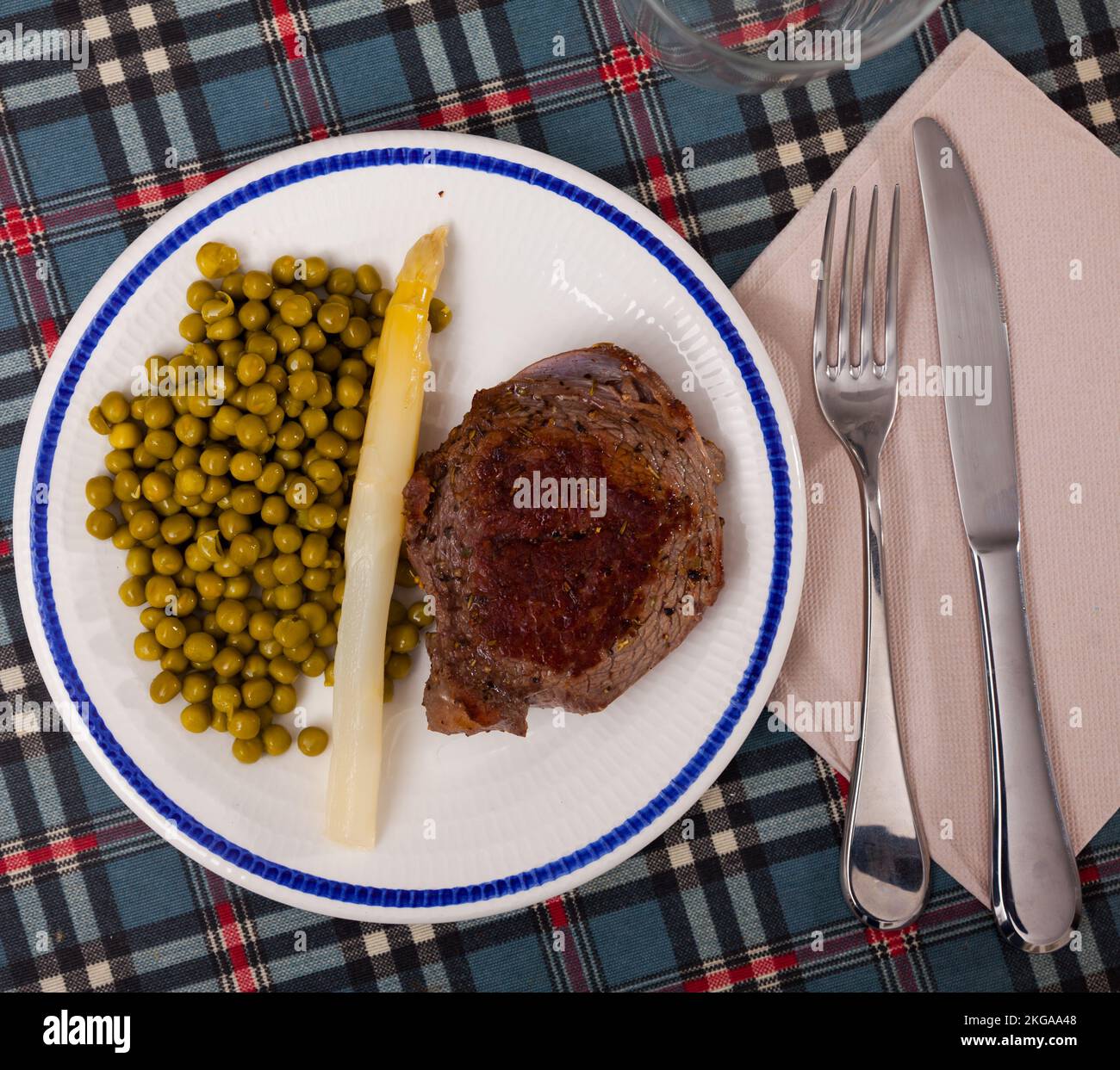 Fried beef cutlet with green peas on plate Stock Photo - Alamy