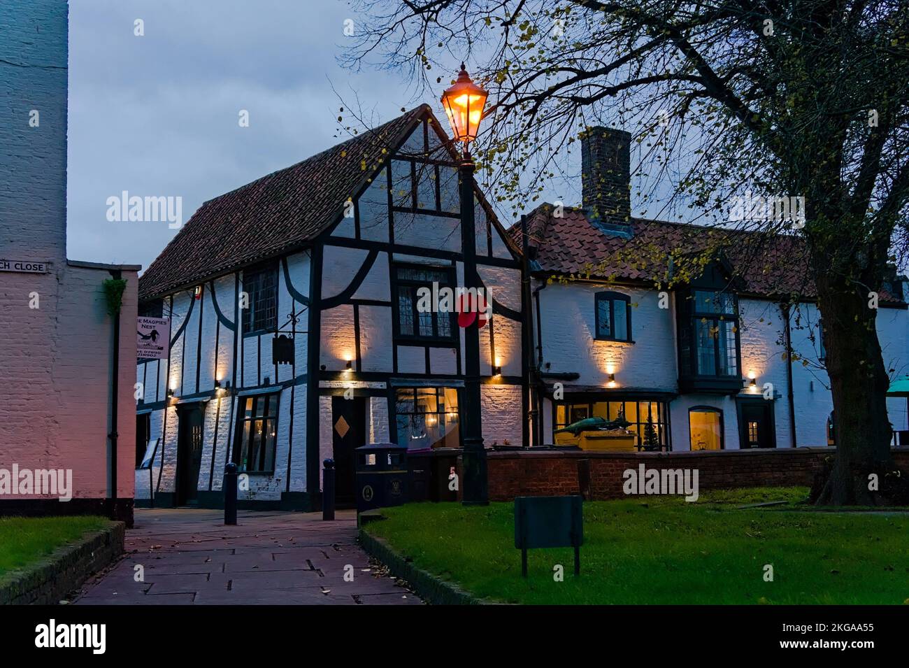 The Tudor-style Church Keys Wine Bar & Restaurant lit up at dusk Stock ...