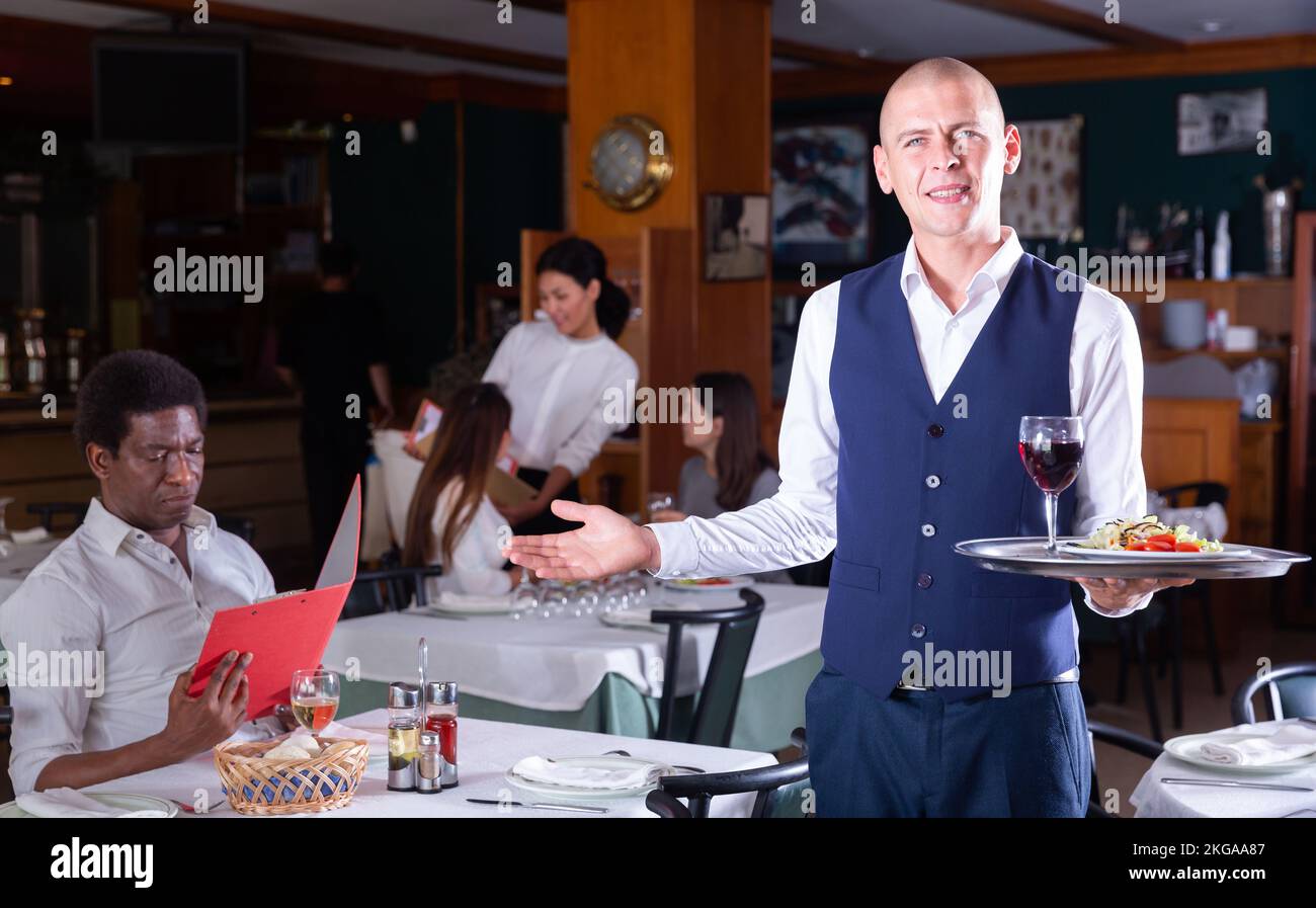portrait of adult happy male garson standing in cafe Stock Photo - Alamy