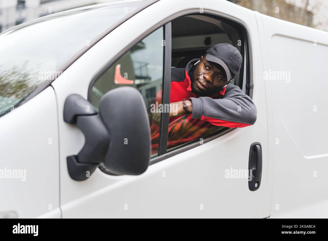 Handsome bearded Black deliveryman dressed in black baseball hat and ...