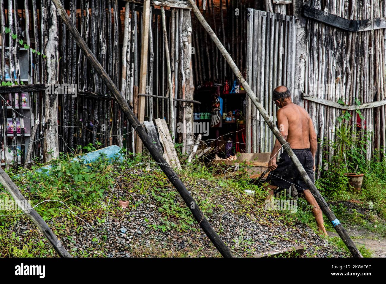 Worker man carrying goods in a wheelbarrow to the store through the ...