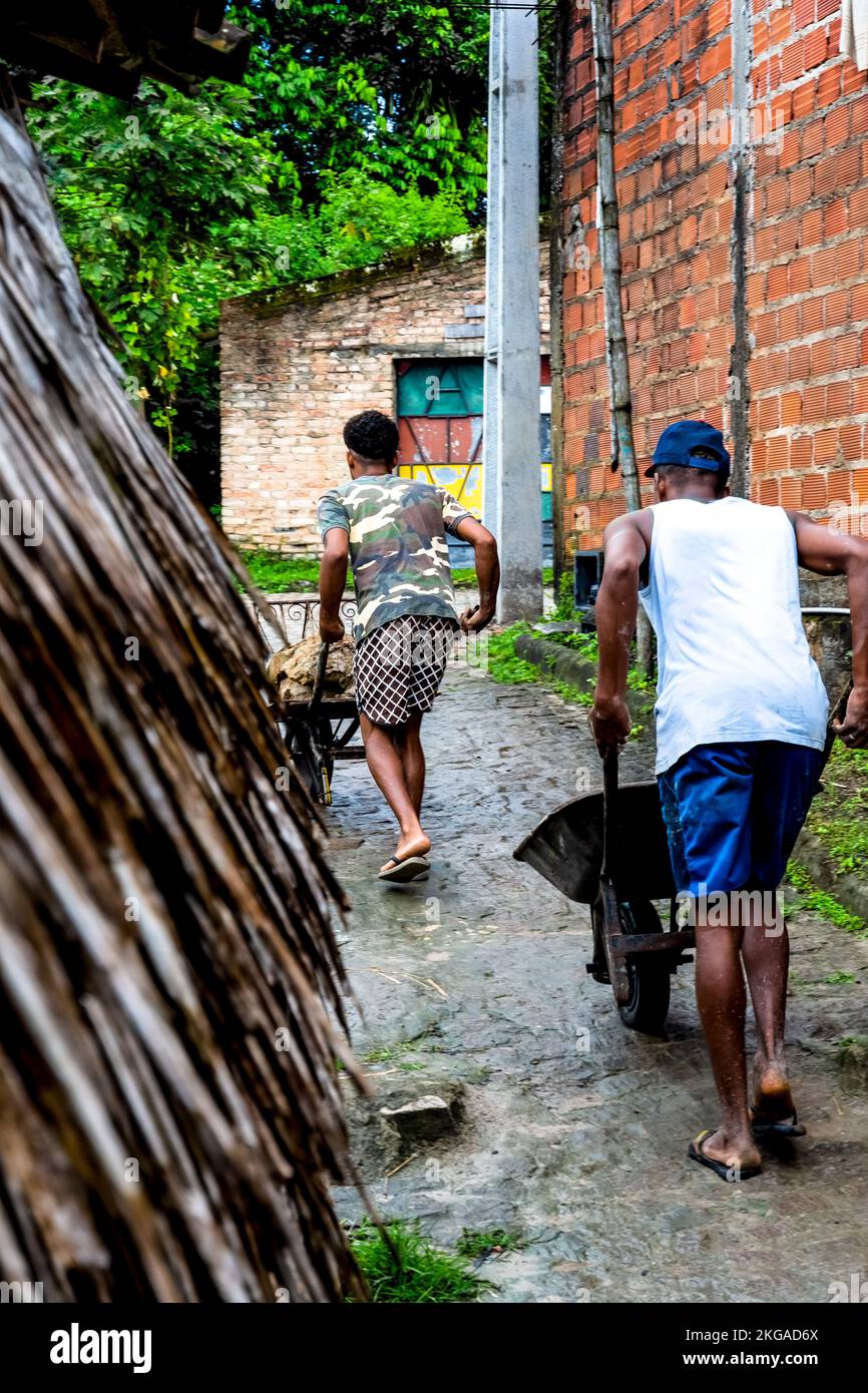 Two men, workers, carrying goods to the store through the streets of ...