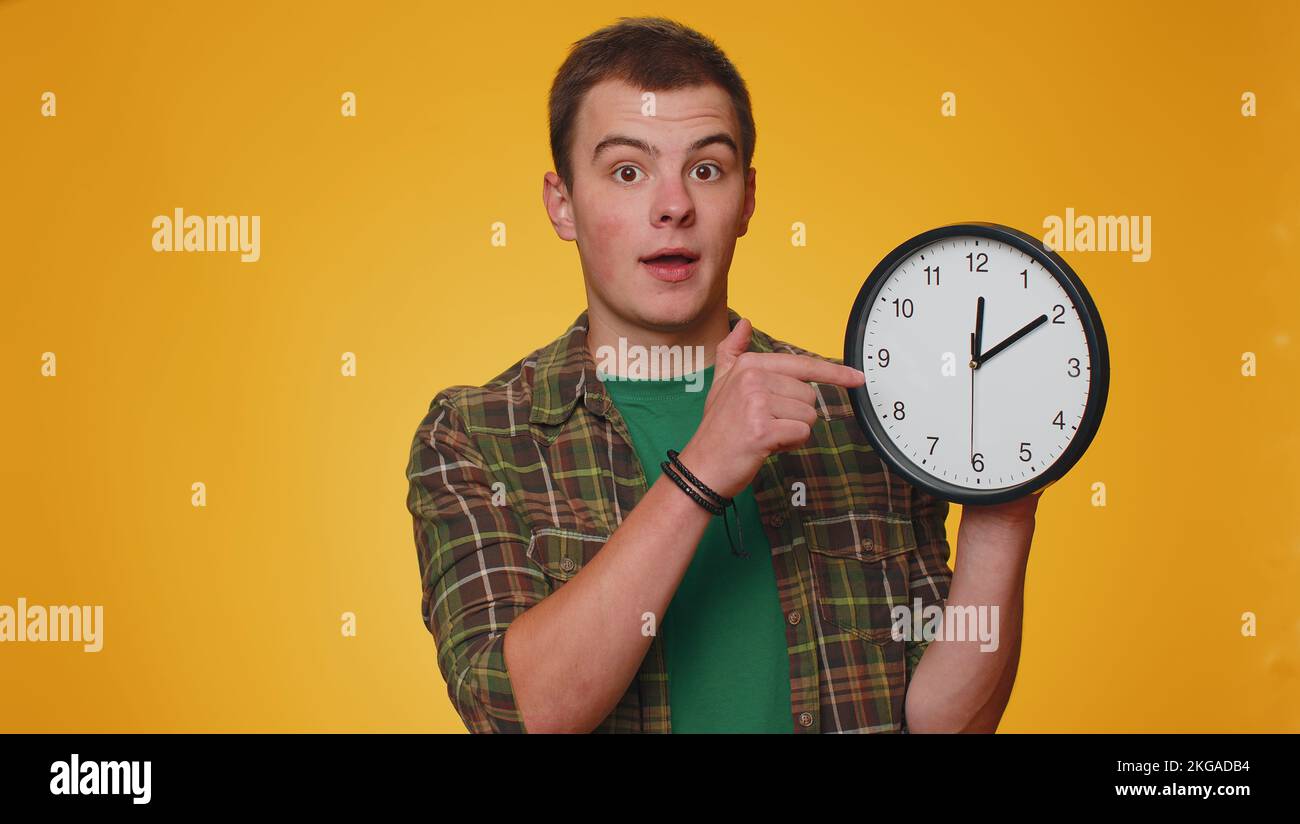 It is your time. Portrait of teen young man in shirt showing time on ...