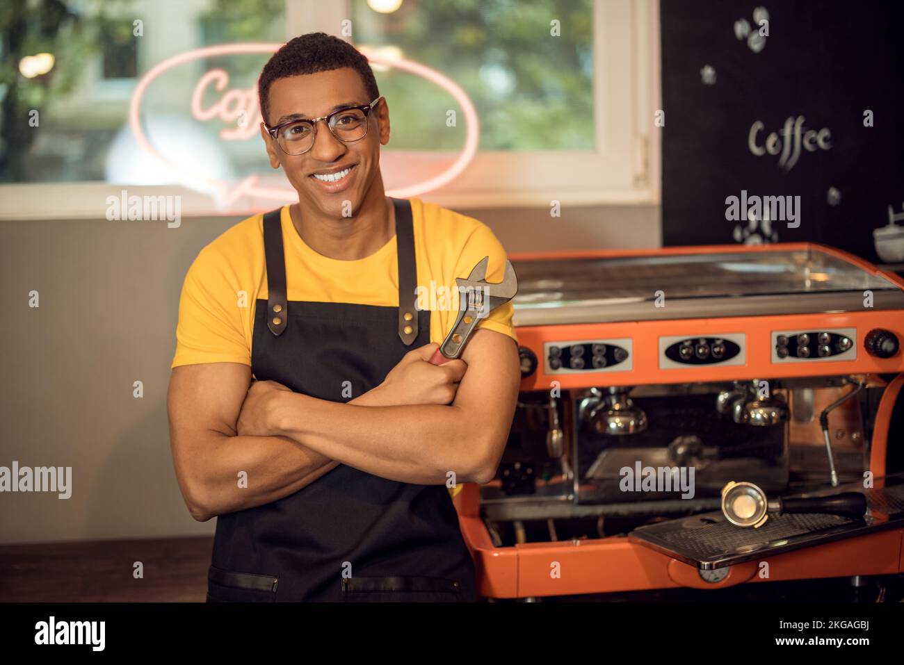 Cheerful coffee machine technician posing for the camera at work Stock ...