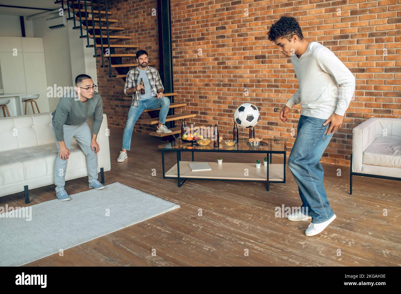 Company of friends involved in an indoor sports game Stock Photo - Alamy