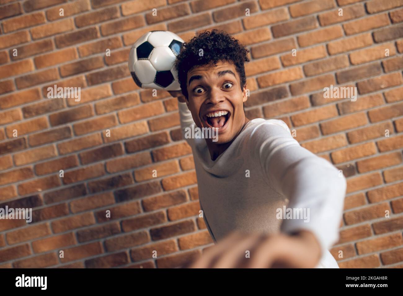 Energetic footballer playing football before the camera Stock Photo - Alamy