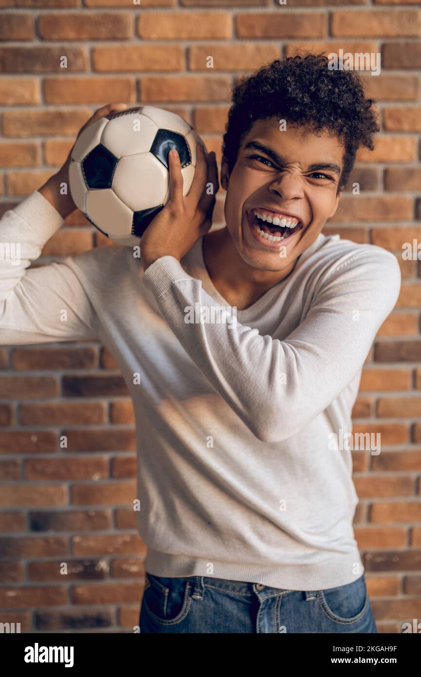 Aggressive football player posing for the camera indoors Stock Photo ...