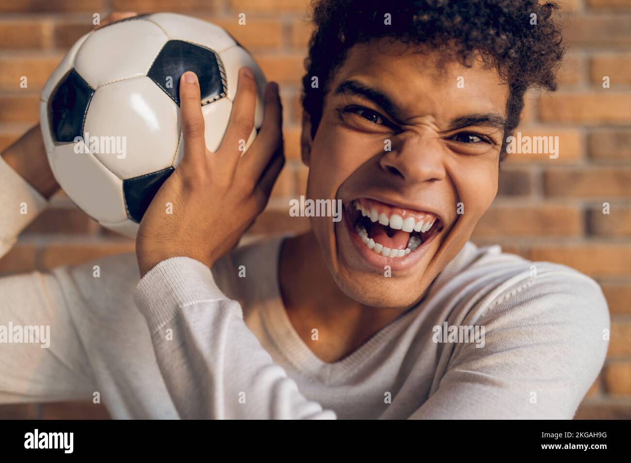Aggressive footballer posing for the camera indoors Stock Photo - Alamy