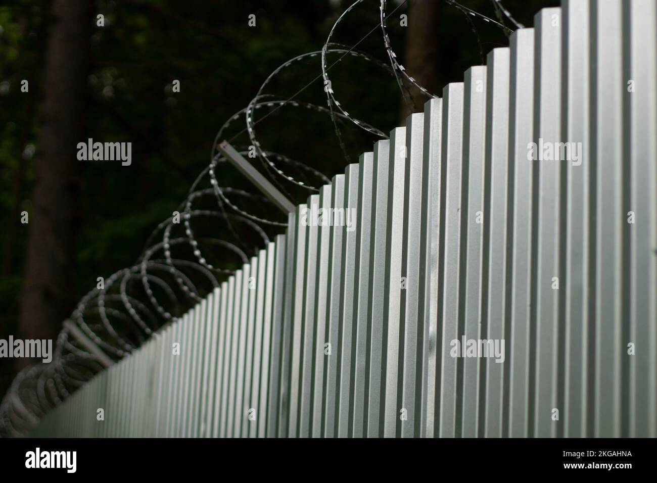 Steel fence with barbed wire. Fence around plant. Private territory ...