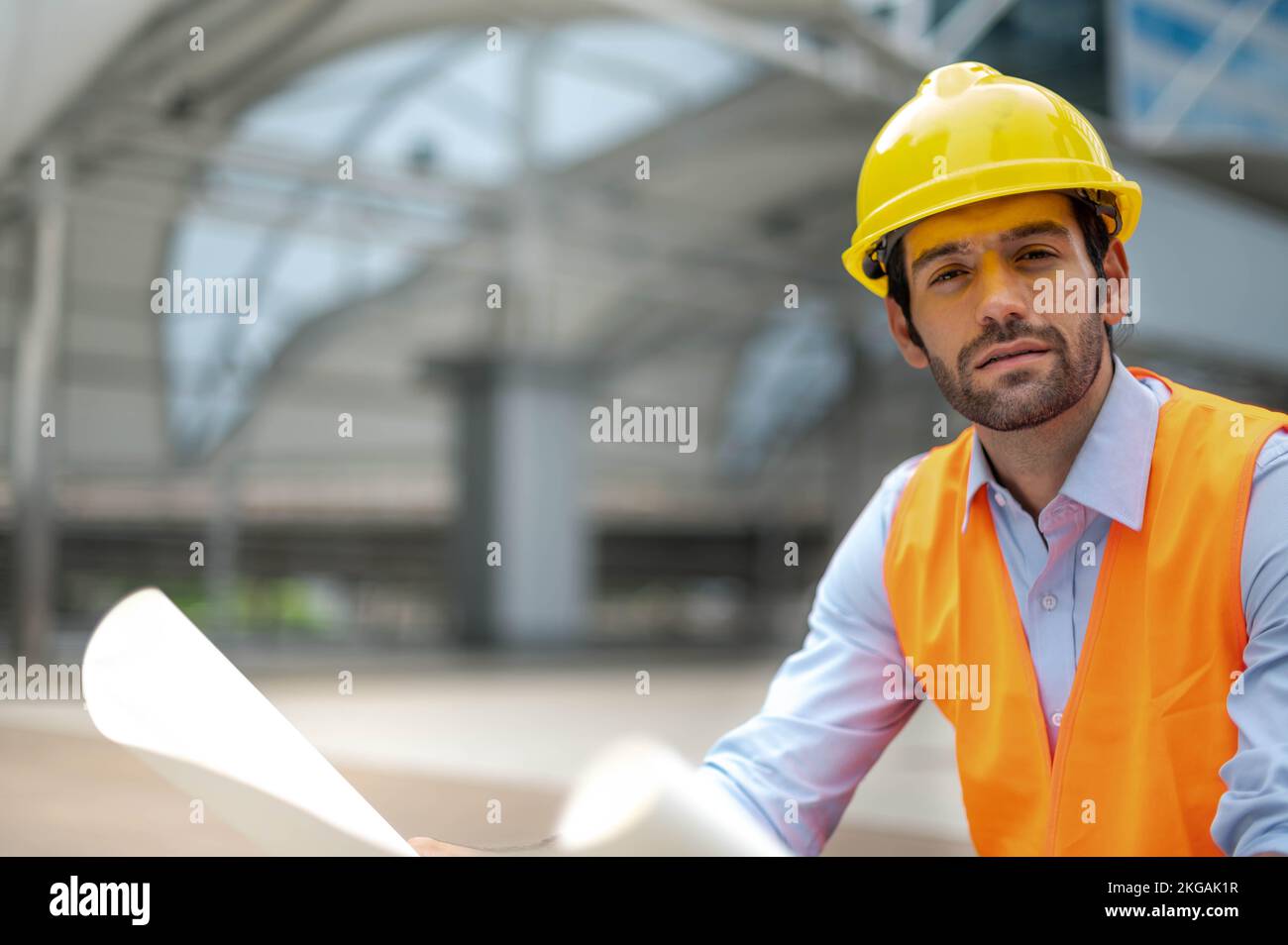 Caucasian man engineer wearing an orange vest and a big hard hat, and ...